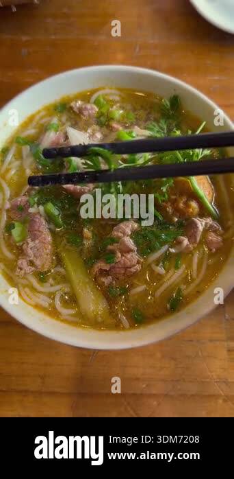 Close-up of traditional pho noodle soup eaten with chopsticks ...