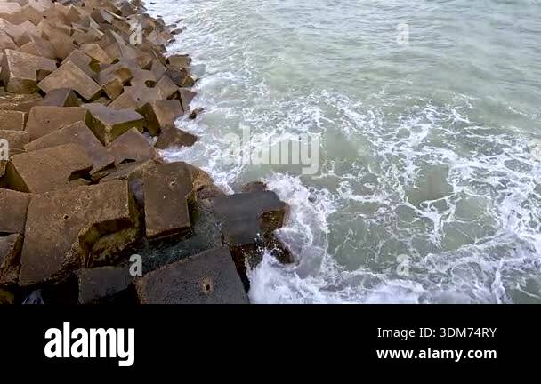 Waves hitting concrete blocks on the shore Stock Video Footage - Alamy