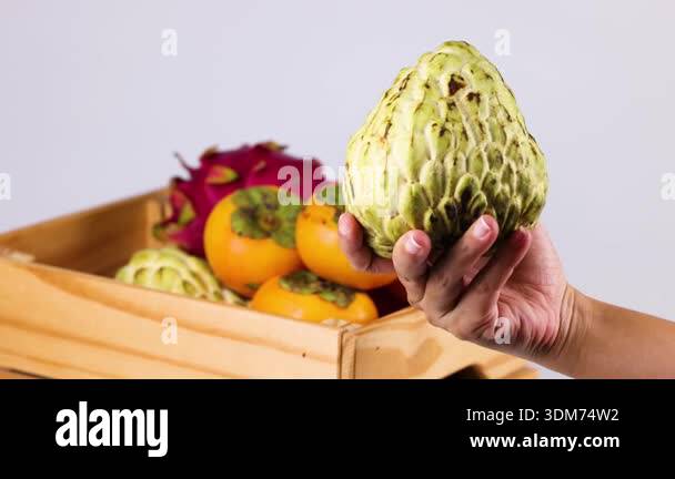 Hand placing custard apple in fruit basket Stock Video Footage - Alamy