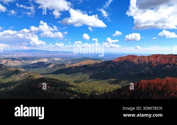 Wooded rocky landscape under blue sky with fluffy clouds. Footage over ...
