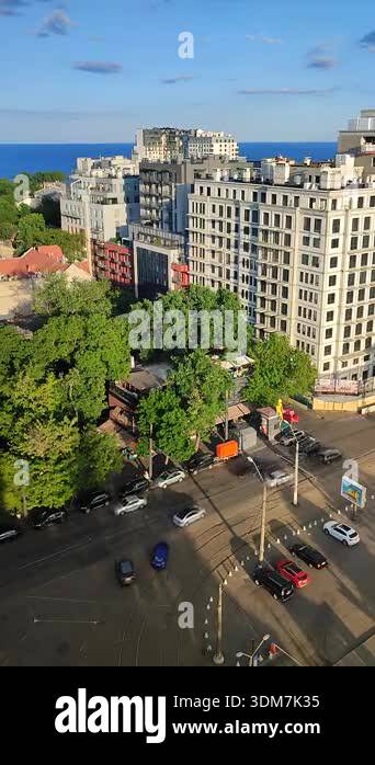 City street view from above. Large multi-story buildings, square, green ...