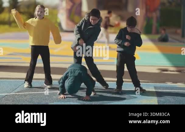 Happy children dancing and breakdancing in a colorful playground during ...