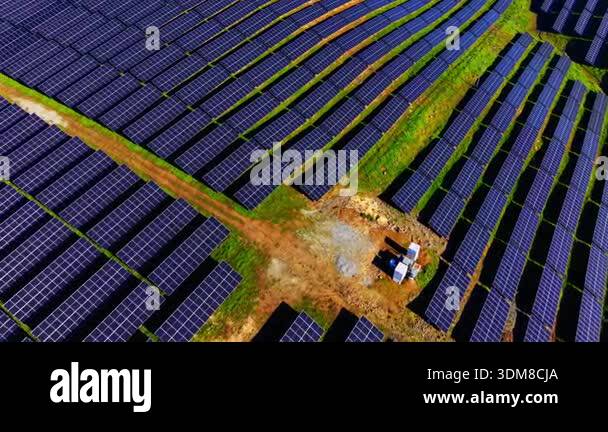 Section of a solar farm with a transformer or inverter unit on a patch ...