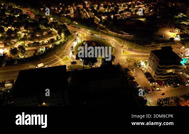 Luminous cityscape featuring an aerial view of a busy roundabout. Cars ...