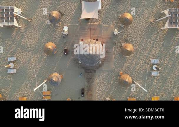 Top-down aerial view of a sandy beach as people arrive at sunrise ...