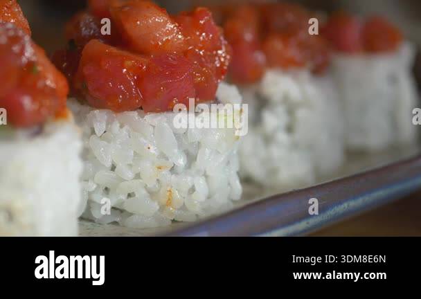 Chef prepares sushi with fresh fish and rice in a kitchen setting Stock ...
