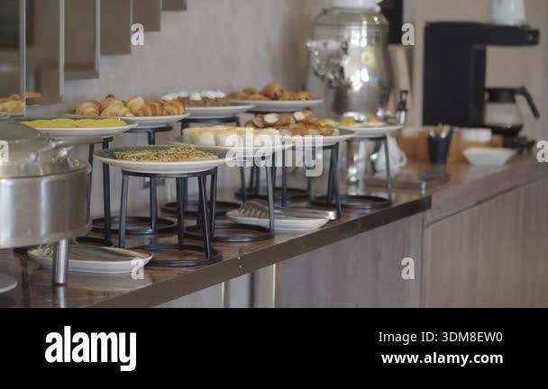 Guests enjoy a variety of pastries and snacks at a hotel breakfast ...