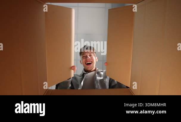 Man looking into cardboard box indoors, view from inside package Stock ...