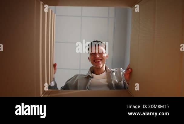 Man looking into cardboard box indoors, view from inside package Stock ...