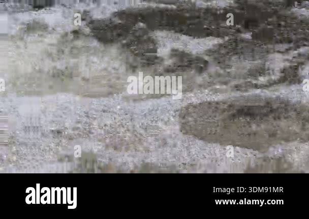 Top view of water rushing over a rocky ledge creating white foam and ...