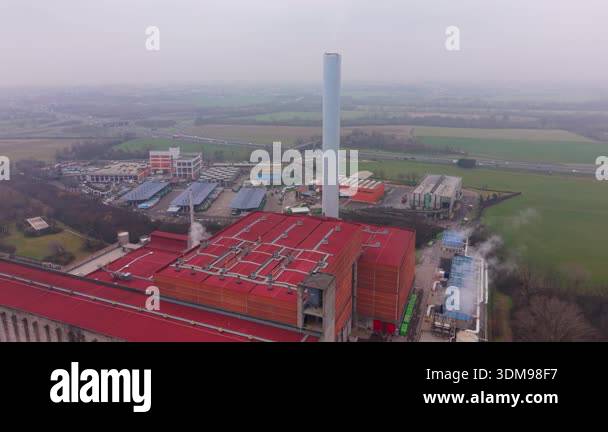 Large industrial complex featuring a prominent smokestack releasing ...