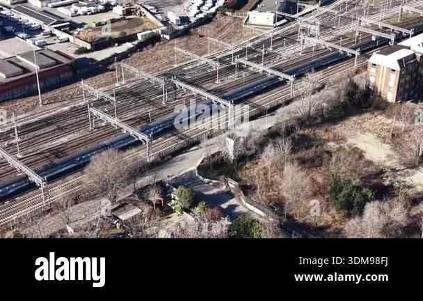 Elevated drone perspective of passenger trains moving along a complex ...