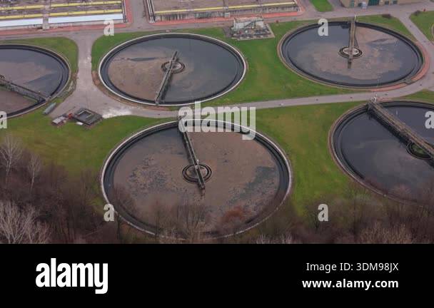 Top-down aerial view of a sewage treatment plant with circular ...
