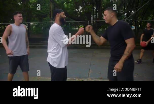 Friends greeting each other with dap handshake on outdoor basketball ...