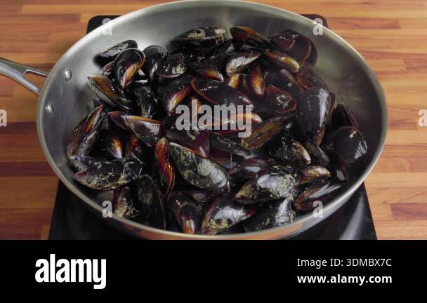 Close up of fresh raw mussels placed in a stainless steel pan on a ...