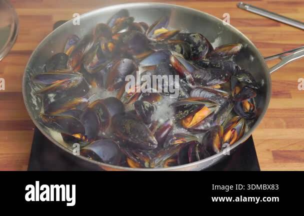 Close up of fresh raw mussels placed in a stainless steel pan on a ...