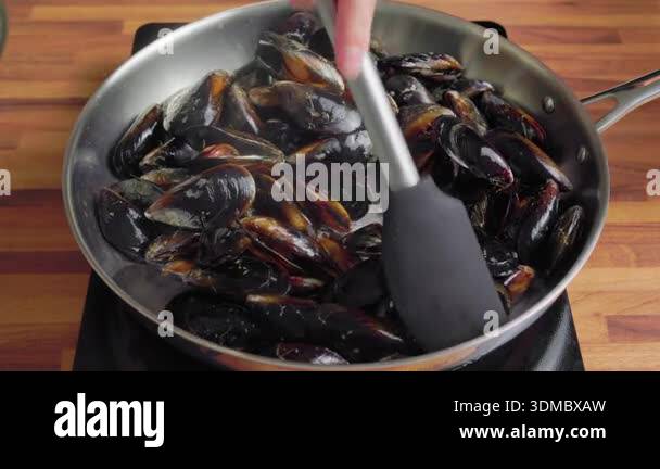 Close up of fresh raw mussels placed in a stainless steel pan on a ...