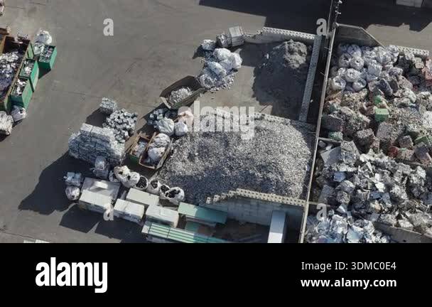 Drone perspective of a recycling yard with large piles of scrap metal ...