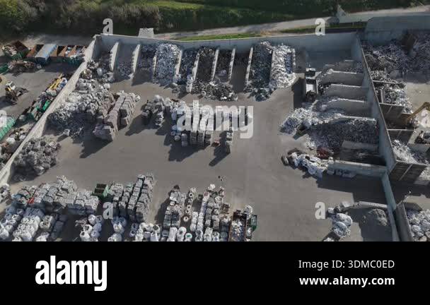 Aerial perspective of a scrap metal recycling yard with large piles of ...