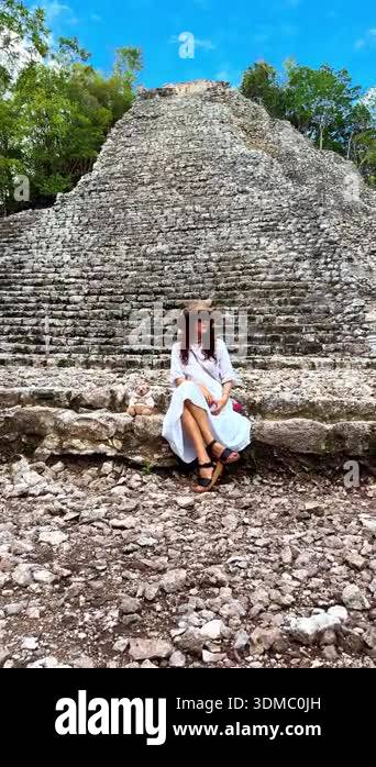 Tourist at ancient Mayan pyramid. Woman resting on stone steps of ...