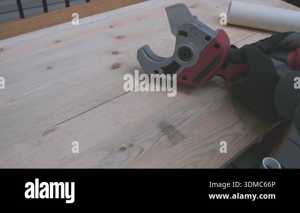 Cutting a plastic pipe with a battery powered pipe cutter Stock Video ...