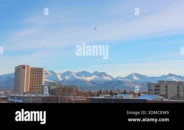 Sheraton Hotel in Anchorage on a winter day, surrounded by snow- capped ...