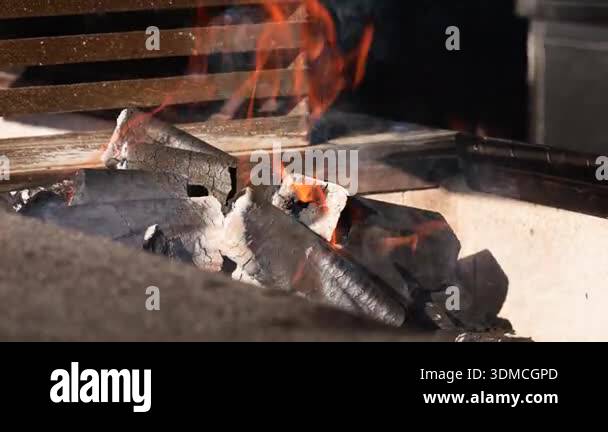 Warm fire burning on a grill. Logs glowing with orange flames. Perfect ...
