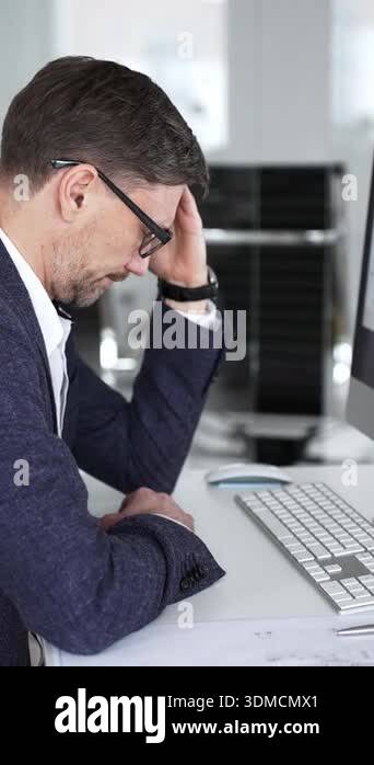 Overwhelmed male architect suffering from headache and eye strain while ...