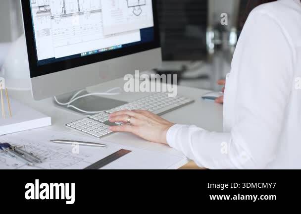 Woman architects hands typing on keyboard, manipulating mouse, working ...
