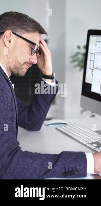 Overwhelmed male architect suffering from headache and eye strain while ...