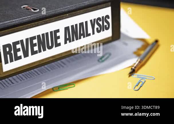 Revenue analysis binder with financial documents and pen on desk for ...