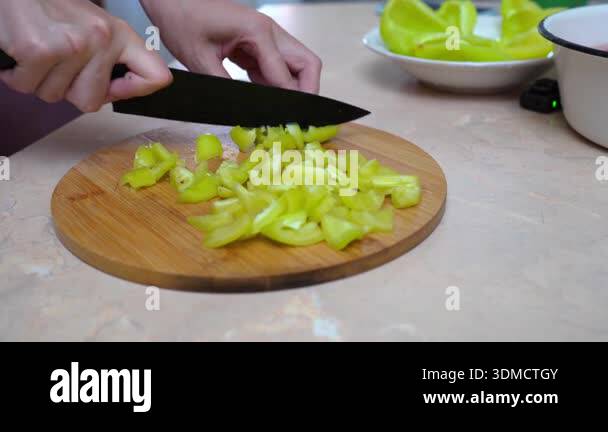 Hand slicing pepper. Detailed view of hand cutting colorful vegetable ...