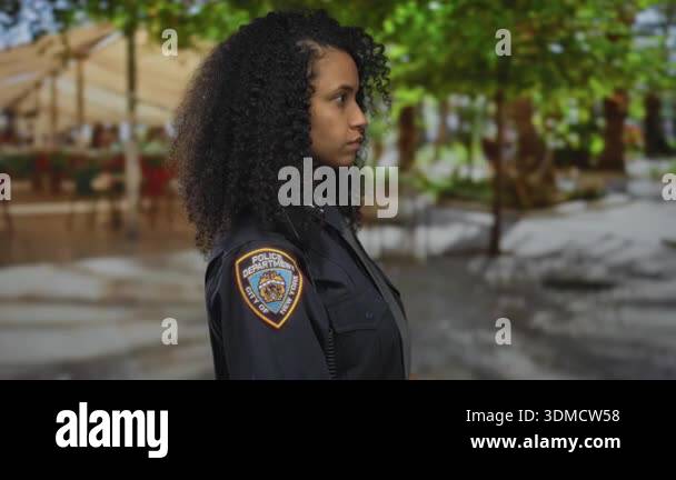 Woman police officer standing on a restaurant terrace in a city street ...