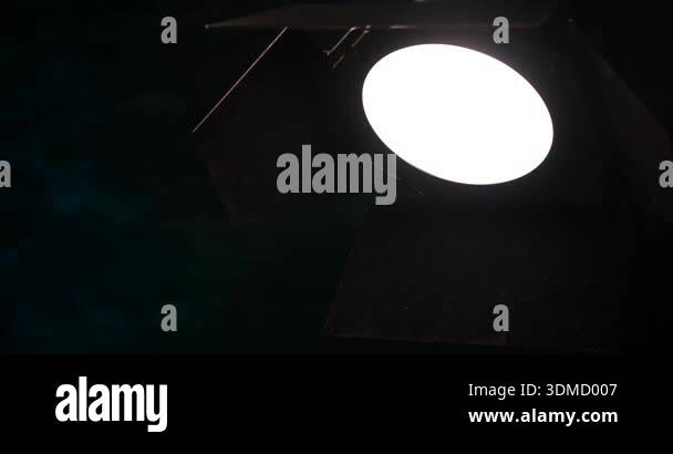 A spotlight is focused on the stage during a live performance ...