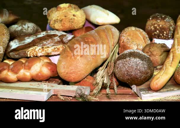 Bakers set up a table filled with various types of bread and baked ...