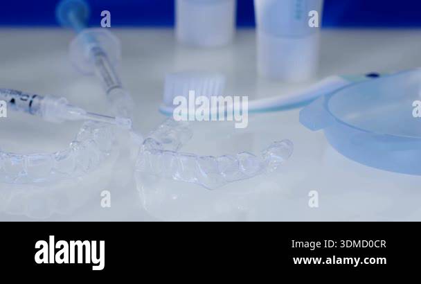 Tools for at-home teeth straightening are arranged on a table. Clear ...