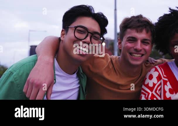 Multirracial group of young smiling friends looking at camera in the ...