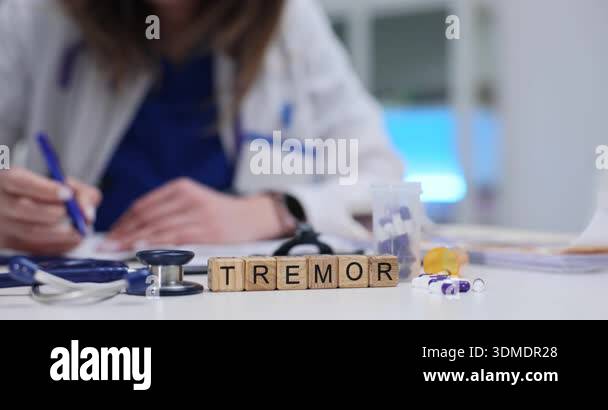 Word Tremor on wooden blocks with stethoscope and pills on desk. Doctor ...