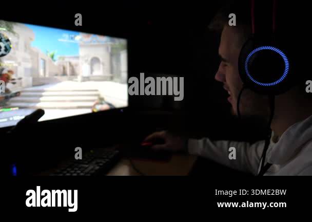 Male gamer playing in first person shooter on computer at home. Young ...