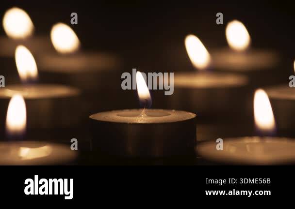 Burning candles in the wind at night. Memorial candles and glowing ...