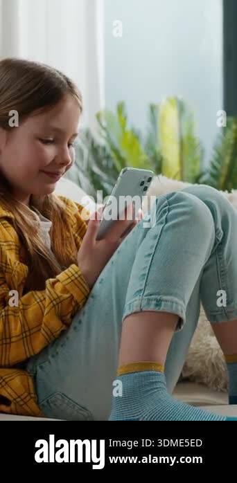 Gadget addict Caucasian little child girl using mobile phone at home ...