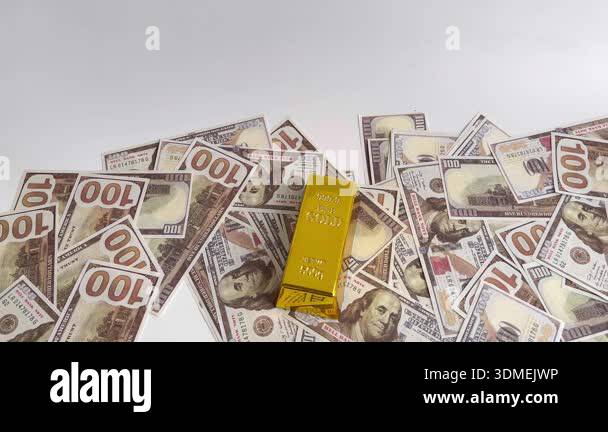 A close-up view of gold bullion and dollar bills for investment ...