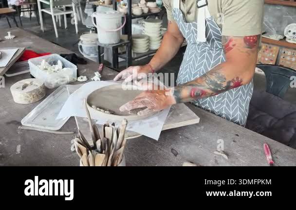 An adult man makes a ceramic plate in a workshop Stock Video Footage ...