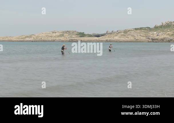 Traditional coastal lifestyle: Villagers foraging for seafood on the ...
