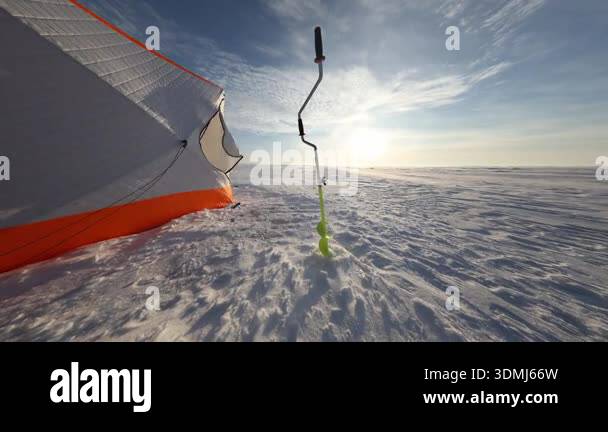 A bright green hand auger stands in a drilled hole beside an orange and ...