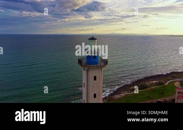 The striking lighthouse rises above tranquil waters during sunset ...