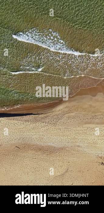 Early morning sunlight sparkles on the green water of the beach, with ...