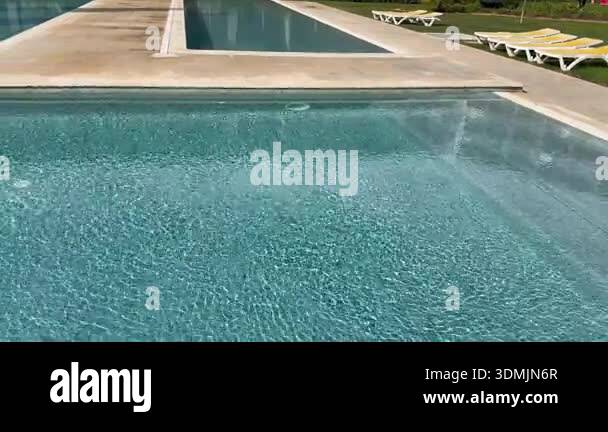 White stone edge of pool and blue pool water texture. Top view, copy ...