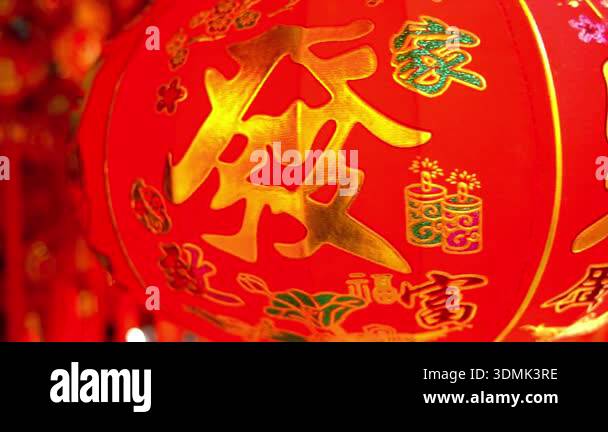 Vibrant red Chinese lantern with intricate golden characters ...