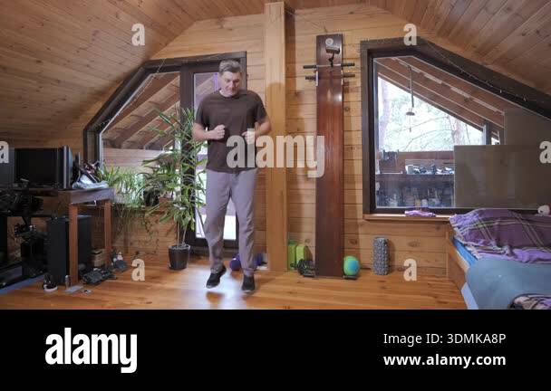 Man jogging in place during home cardio workout, Indoor aerobic ...